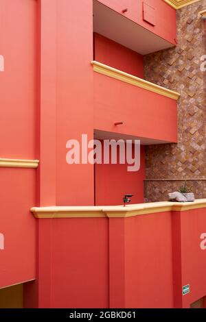Salmon-colored hotel facade with symmetrical windows Stock Photo - Alamy