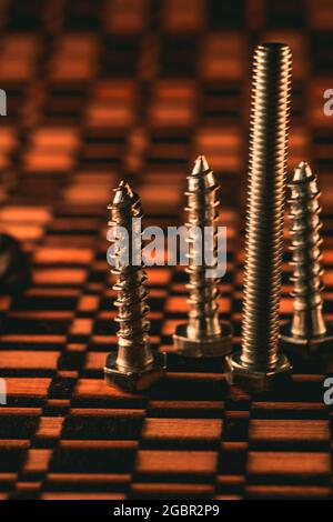 Vertical closeup of golden screws and bolts on the checkerboard Stock ...