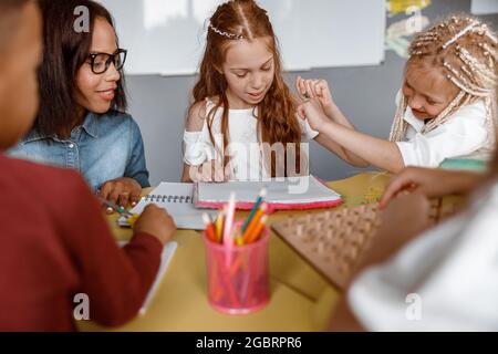 Children drawing on a notebook while sitting in a park Stock Photo - Alamy