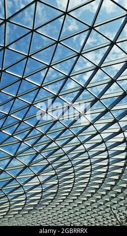 Vertical low angle shot of a geometrical buildings under the clear blue ...