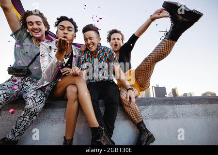 Friends celebrating gay pride while sitting together. Four members of ...