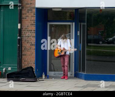 Grantham, Lincolnshire, UK - A busker with a guitar playing in an empty ...