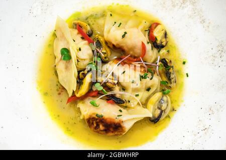 Dumplings Gyoza with crab filling served with mussels and microgreens ...