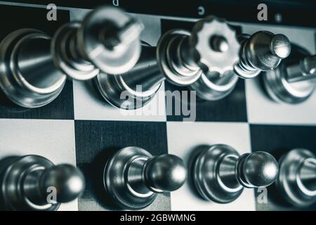 Closeup shot of an arranged chessboard with metallic silver pieces ...