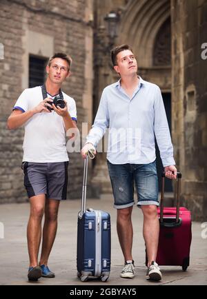 Happy tourists friends. Two guys and one attractive woman in swimwear ...