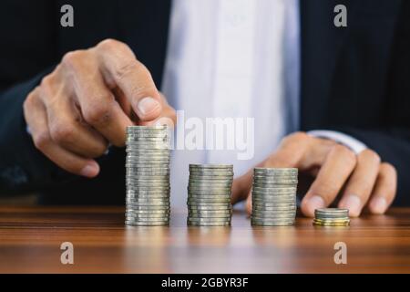 Hand counting coins stack on wooden table, Cons stack saving money or ...