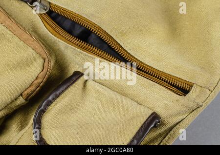 Close-up of a fragment of a shoulder bag on a gray background. Olive ...