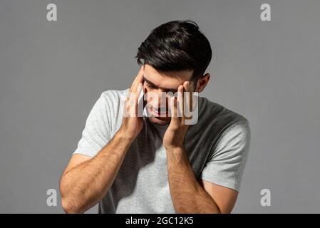 Young tired, fatigued man with worried face, stressed, dragging face ...