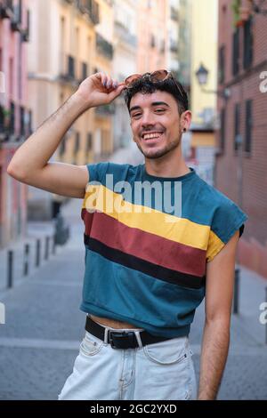 Young caucasian man with false nails using the phone standing against a ...