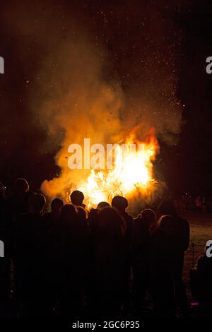 Audience watches a large bonfire, as part of a fireworks spectacular ...