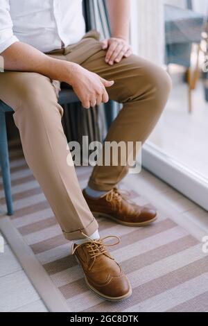 Elegant groom in brown costume, bow-tie and suspenders Stock Photo - Alamy