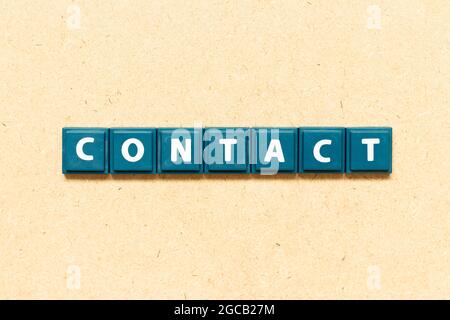 Tile alphabet letter with word contact in red color rack on wood ...