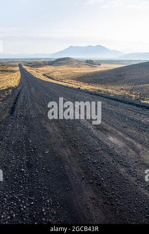 Snow covered country road between winter wheat fields in early spring ...
