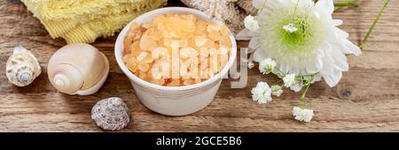 Soft towels, sea salt and shells on wooden background. Spa concept ...