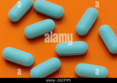Pills are scattered over a blue background with a copy of space Stock ...
