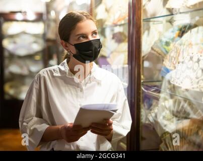 Woman in mask observing artworks in museum Stock Photo - Alamy