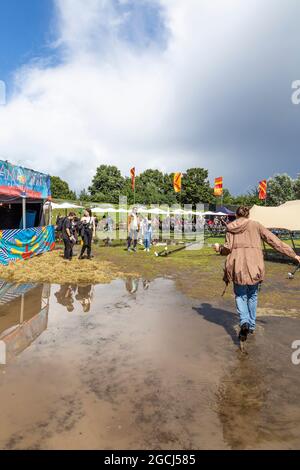 Festival-goers jump over a puddle of rain at the Lollapalooza Festival ...