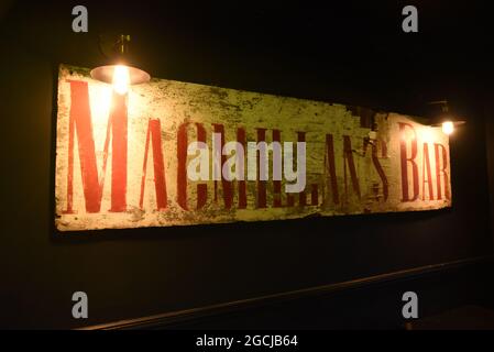 Macmillans bar sign illuminated Stock Photo - Alamy