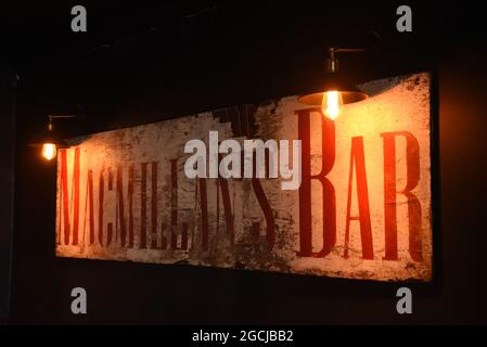 Macmillans bar sign illuminated Stock Photo - Alamy