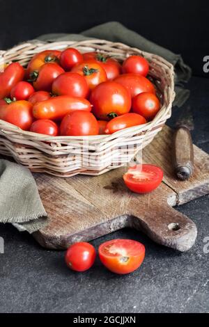 Fresh red tomatoes in whicker basket on black background Stock Photo ...