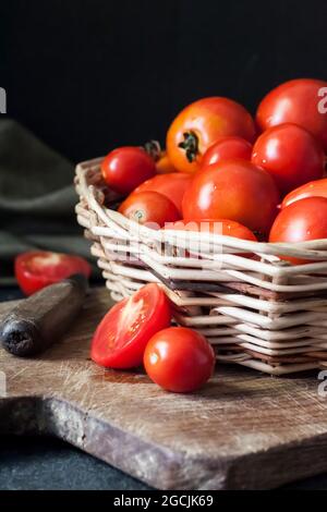 Fresh red tomatoes in whicker basket on black background Stock Photo ...