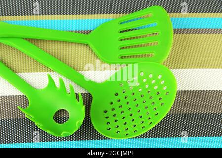 Plastic kitchen utensils on fabric background Stock Photo - Alamy