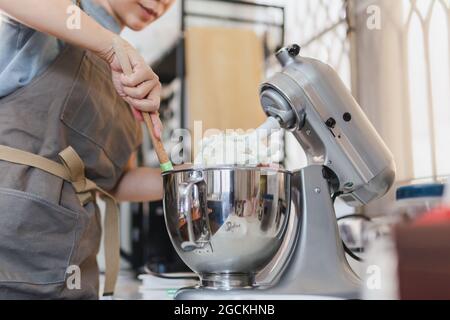 Woman beat dough mixer by machine in bowl at her kitchen Stock Photo ...