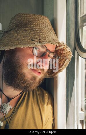 Happy man in earphones waving hand while taking video call on laptop at ...