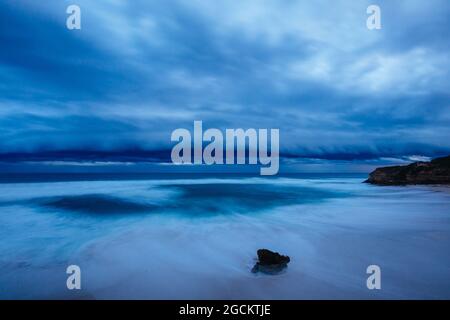 The idyllic Number Sixteen Beach with an incoming storm at dusk in Rye ...