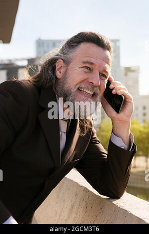 Side view of bearded male entrepreneur on stylish sunglasses while ...