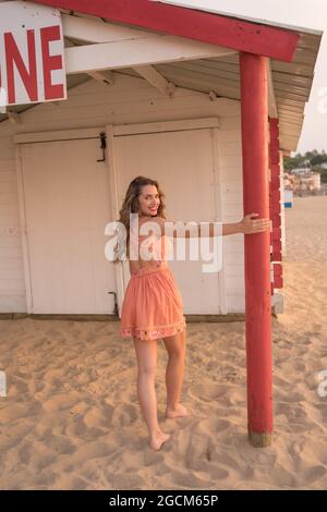 A back view of a cool barefoot woman in a black suit standing near a ...