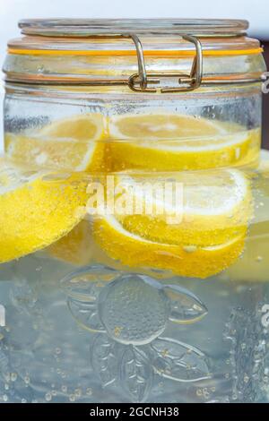Lemon slices in glass jar filled up with refreshing soda. Black ...