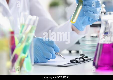 Researcher records data obtained from chemical experiment in laboratory ...