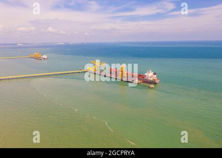 A coal transport ship at the dock of the Jimah Power Plant at the ...