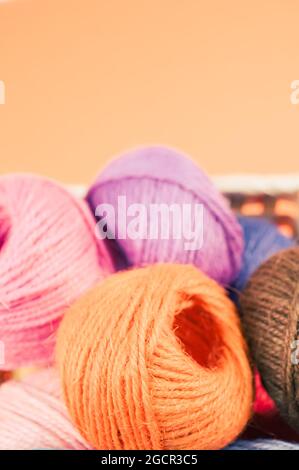 Basket full of colorful yarn rolls isolated on an orange background ...