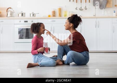 Mother's day concept. Child daughter congratulates mom and gives her ...
