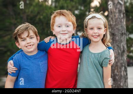 Three children hug as friends in elementary or kindergarten Stock Photo ...