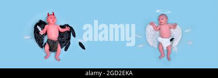 A newborn baby boy with black demon wings on a blue studio background ...