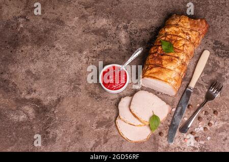 Sliced baked pork loin on a stone concrete background. A trendy hard ...
