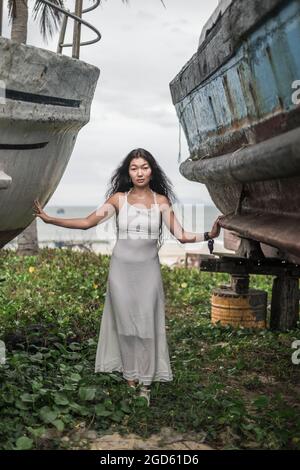 A young pretty Mongolian woman with a white leather jacket and ...