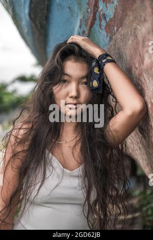 A young pretty Mongolian woman with a white leather jacket and ...