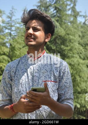 Good-looking handsome man with a phone in hand Stock Photo - Alamy