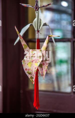 A paper origami bird hanging from a blossoming tree in spring Stock ...