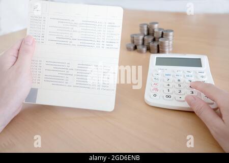 women checking amount in bank account passbook with bank statement ...