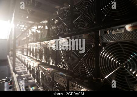 Bitcoin ASIC miners in warehouse. ASIC mining equipment on stand racks ...
