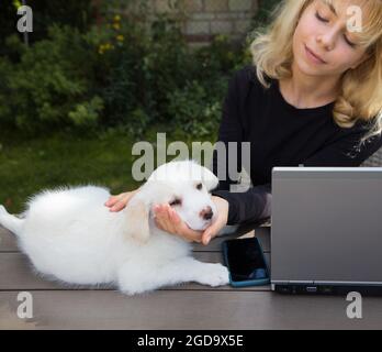 A young woman stands next to a table with fresh vegetables and fruits ...