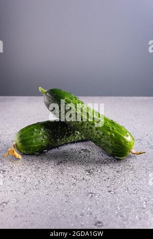 Macro of a cut cucumber with water droplets, isolated on dark ...