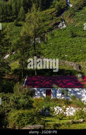Carawaystick waterfall and red roofed whitewashed cottage in Glenmalure ...