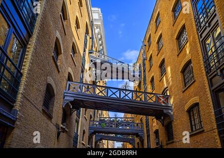 Shad Thames road and wharf bridges behind the old river warehouses ...
