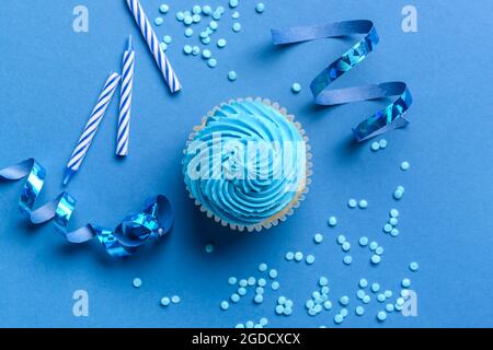 Tasty Birthday cupcakes with candles and ribbons on color background ...